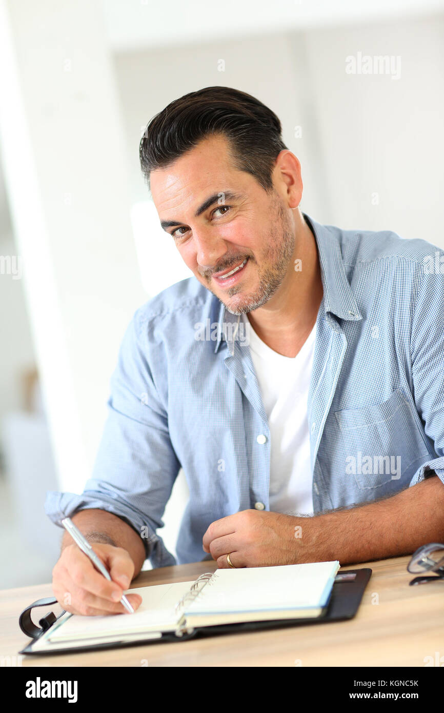 Portrait of salesman writing on agenda Stock Photo - Alamy