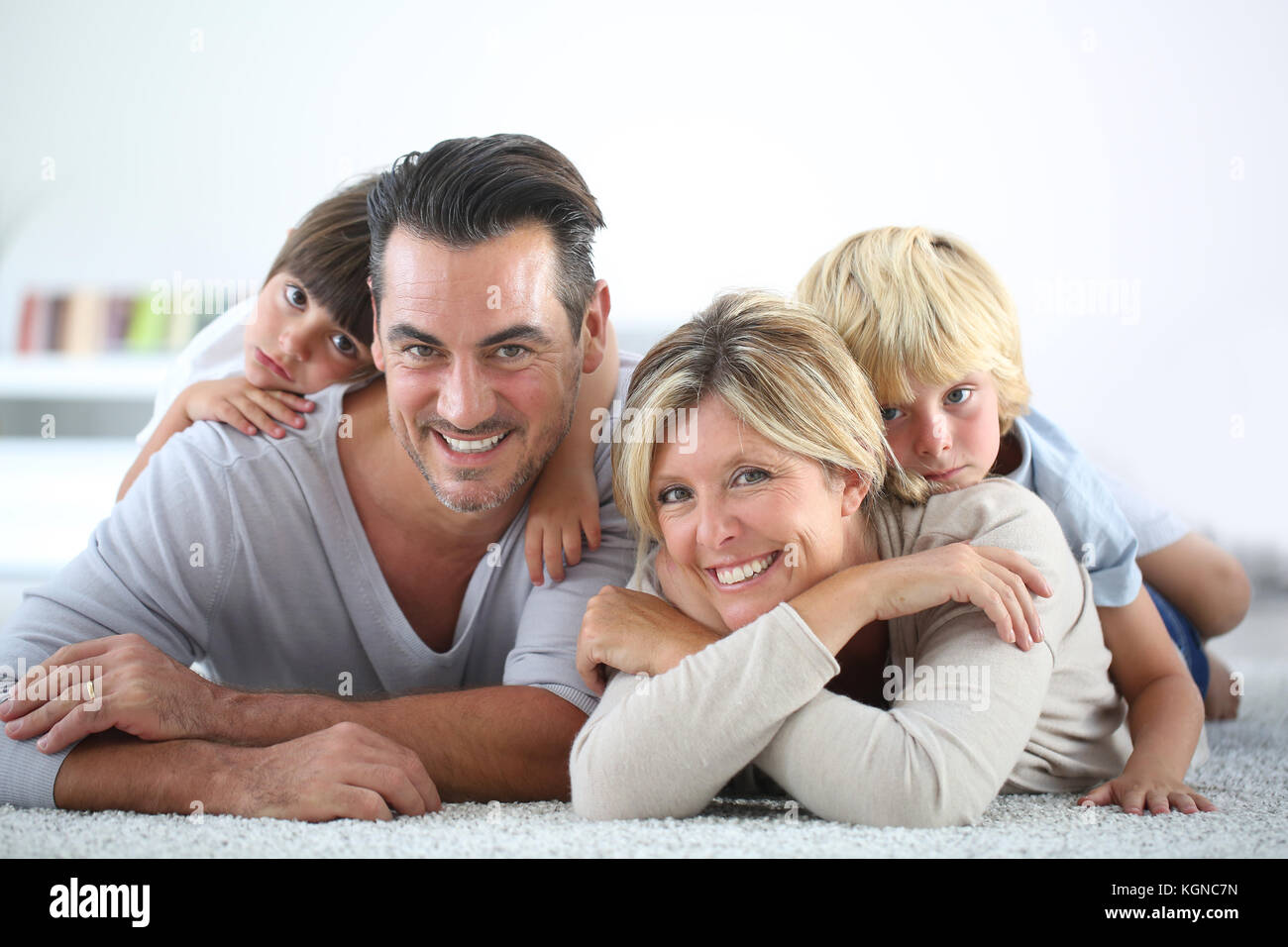 Portrait of happy family laying on carpet Stock Photo - Alamy