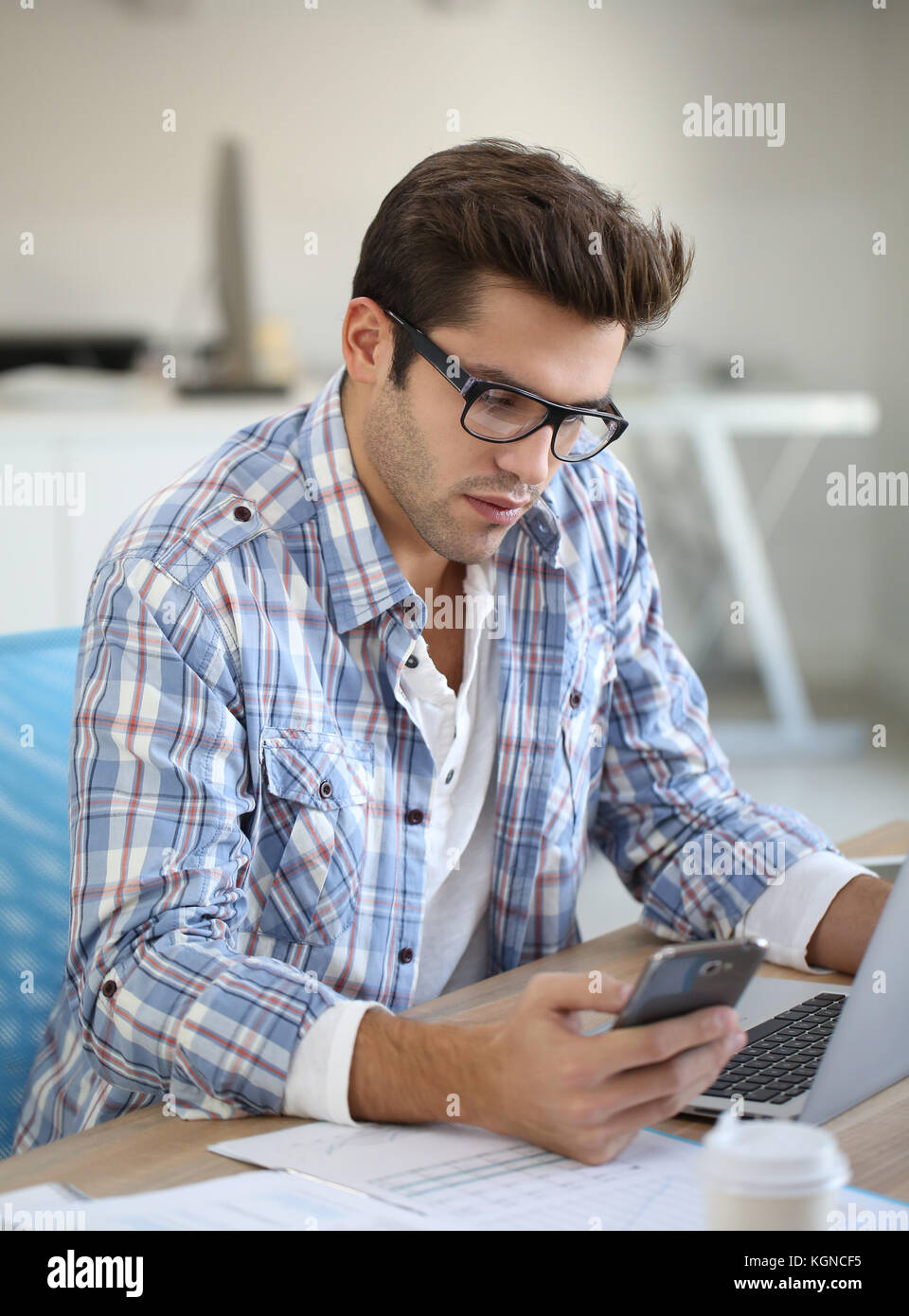 Young man in office working on laptop computer Stock Photo - Alamy