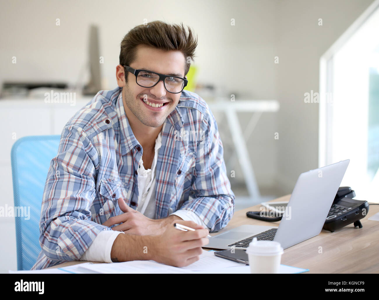 Young man in office working on laptop computer Stock Photo - Alamy
