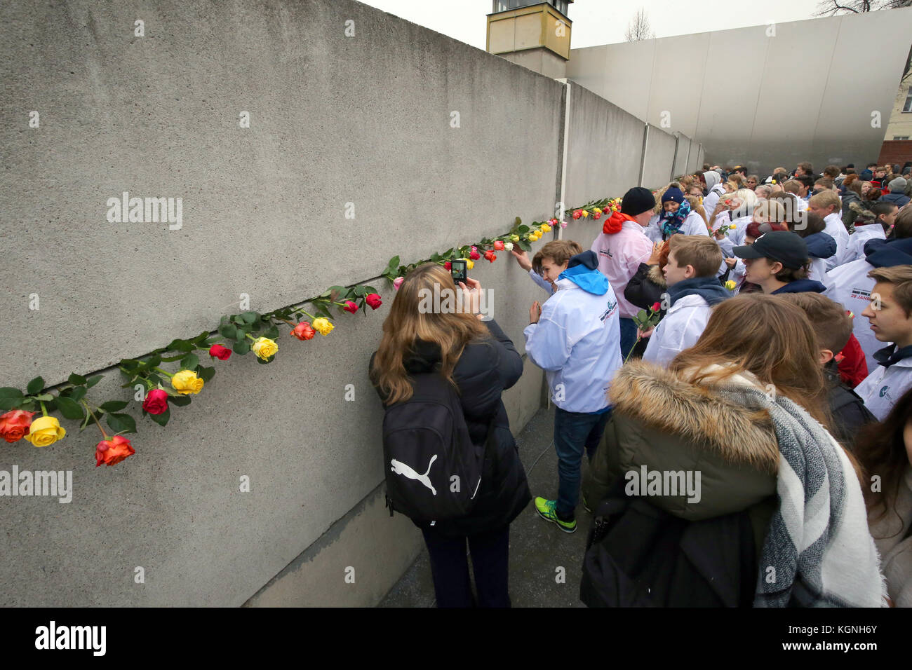 Berlin, Germany. 9th Nov, 2017. Teenagers put roses into the wall ...