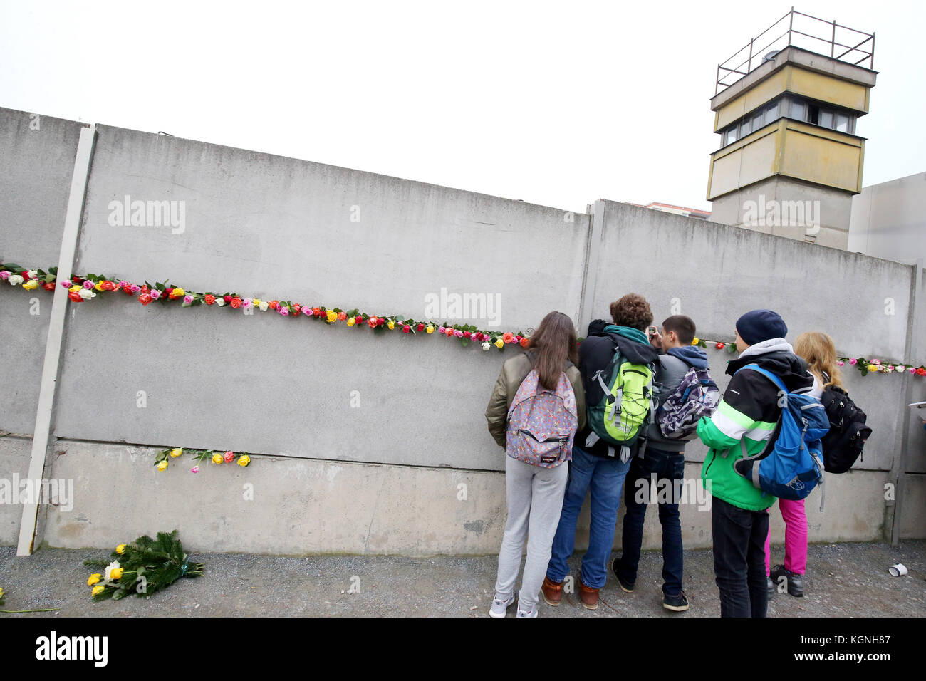 Berlin, Germany. 9th Nov, 2017. Teenagers put roses into the wall ...