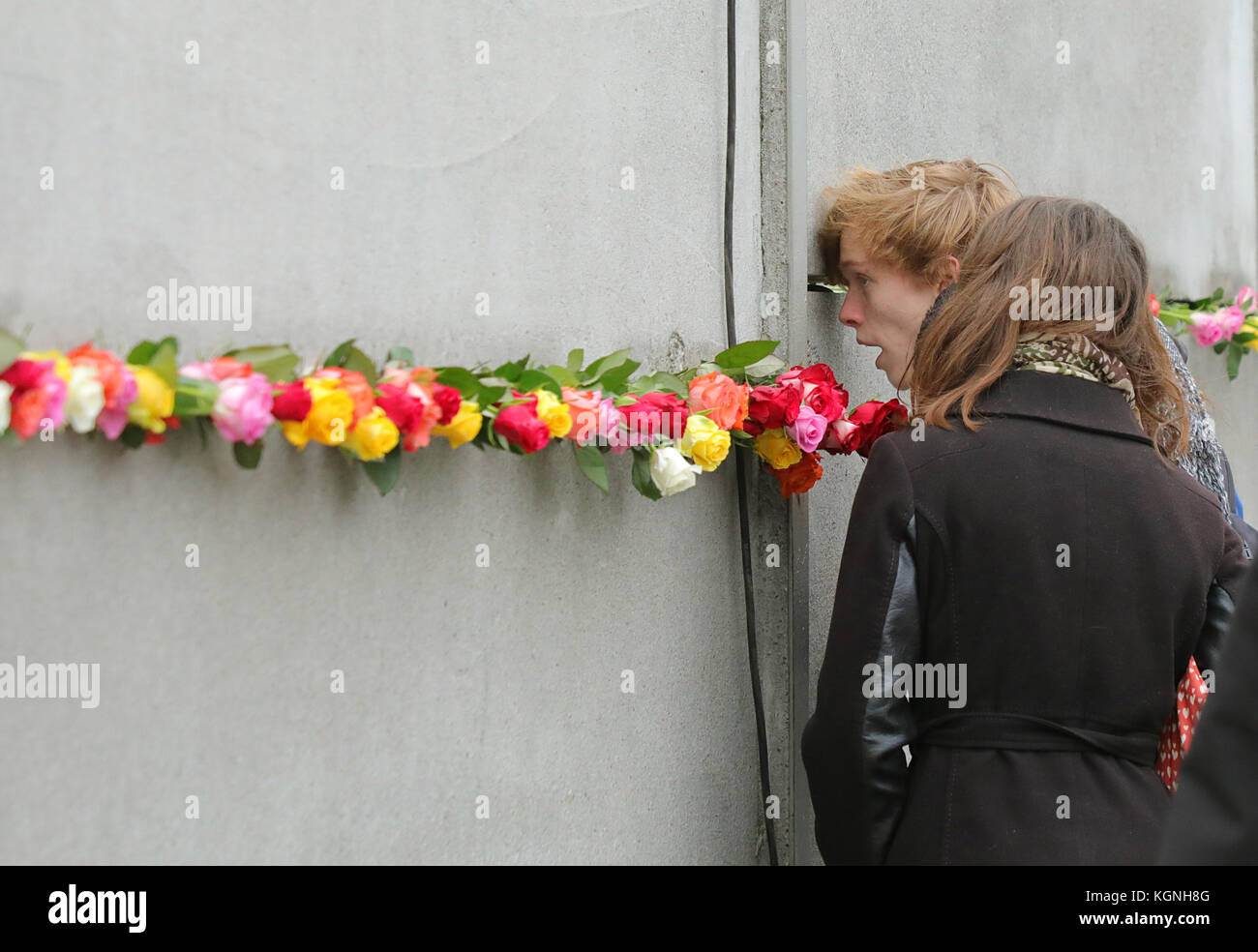 Berlin, Germany. 9th Nov, 2017. Teenagers put roses into the wall ...