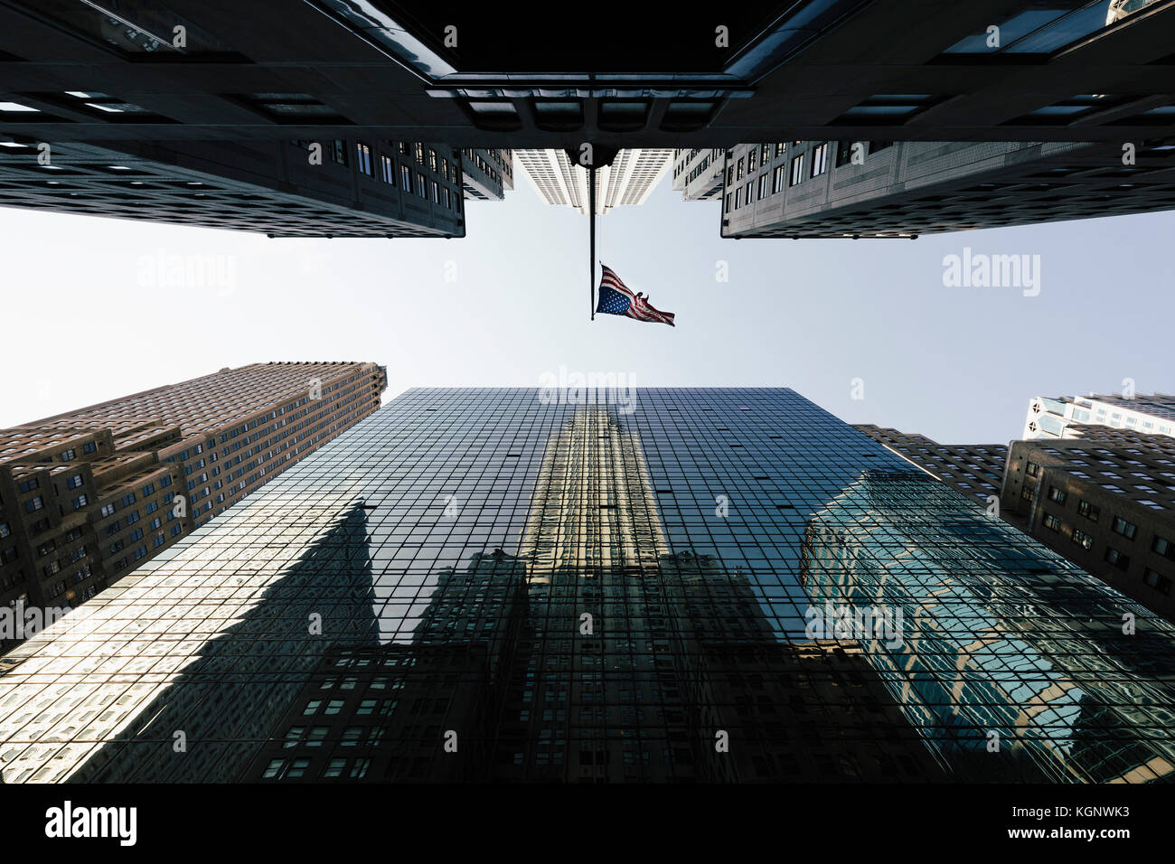 Directly below view of American Flag amidst modern office skyscrapers ...