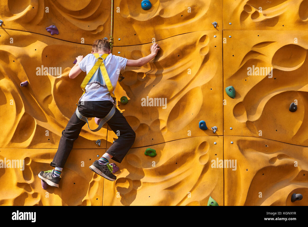 Child climbing a rock wall outdoor - bouldering Stock Photo - Alamy
