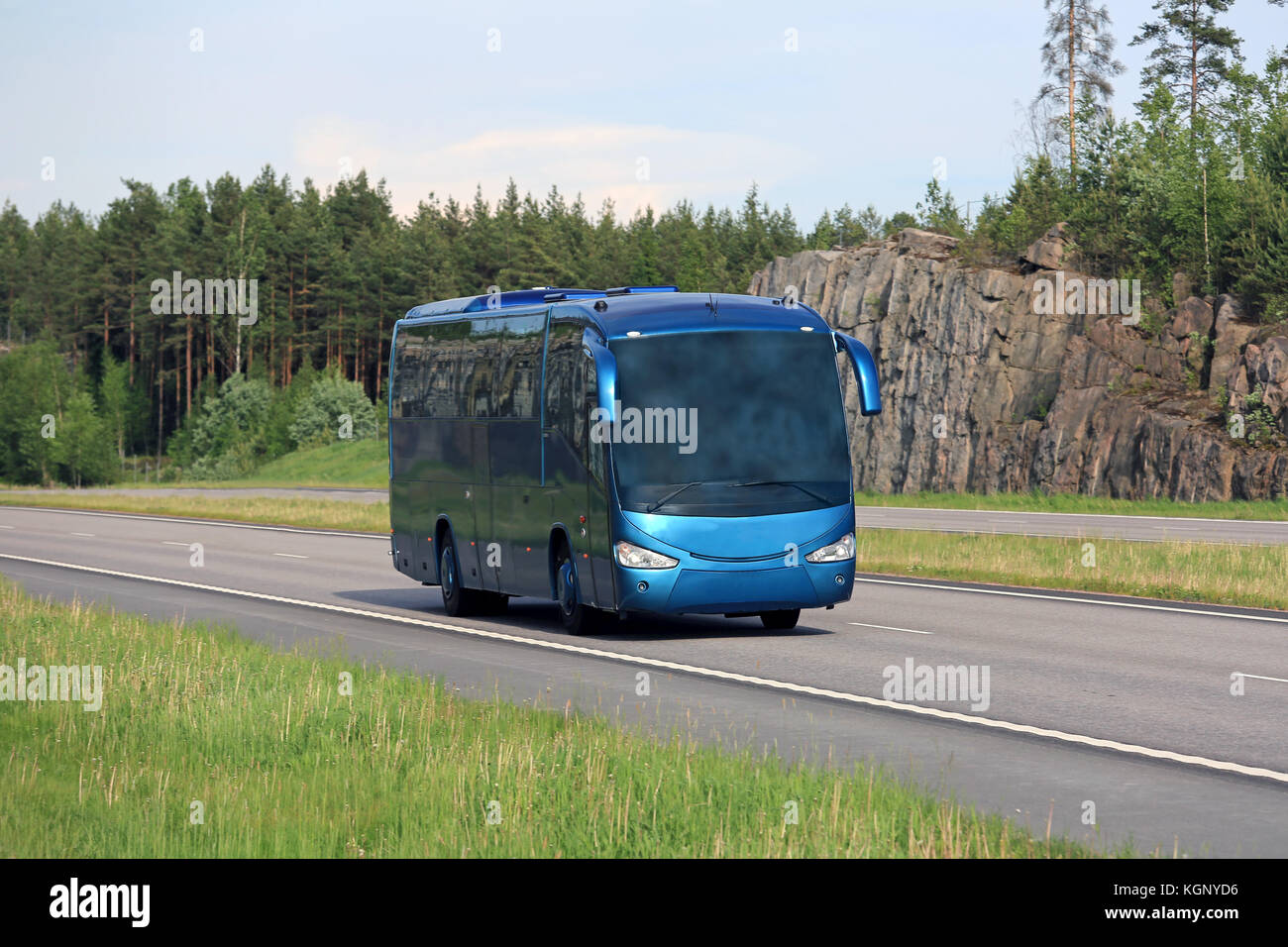 Modern blue coach bus drives on freeway on a clear day of summer. Copy ...