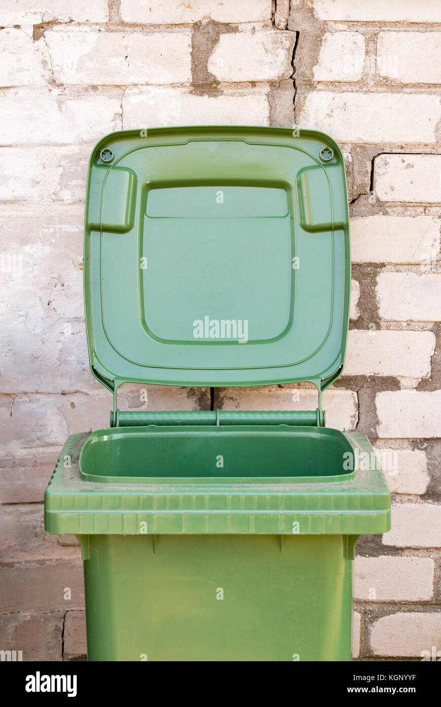 Empty dirty green recycle bin near the brick wall Stock Photo - Alamy
