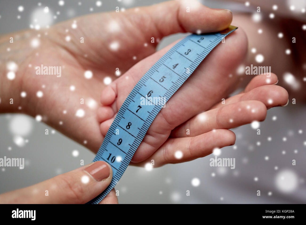 close up of hands with tape measuring baby foot Stock Photo - Alamy