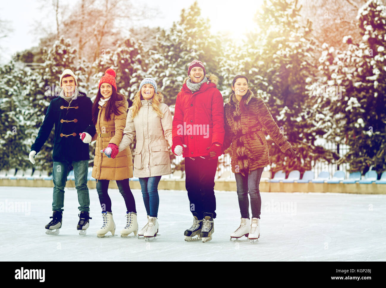 happy friends ice skating on rink outdoors Stock Photo - Alamy