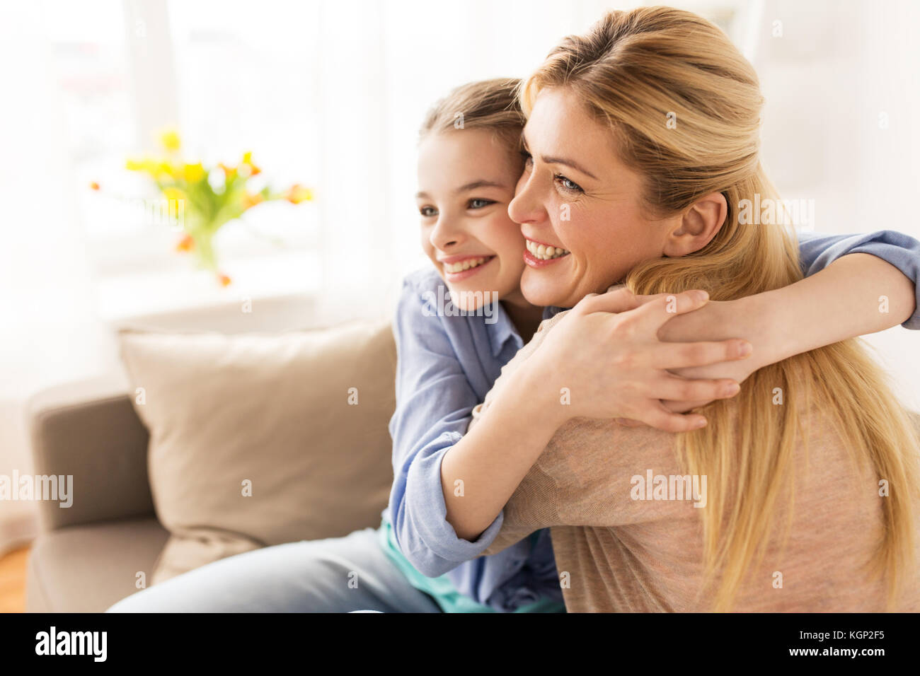 happy smiling family hugging on sofa at home Stock Photo - Alamy