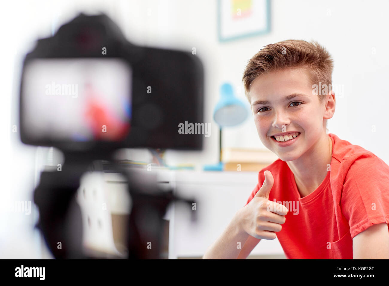 happy boy with camera recording video at home Stock Photo - Alamy