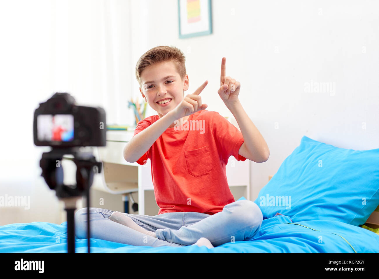 happy boy with camera recording video at home Stock Photo - Alamy