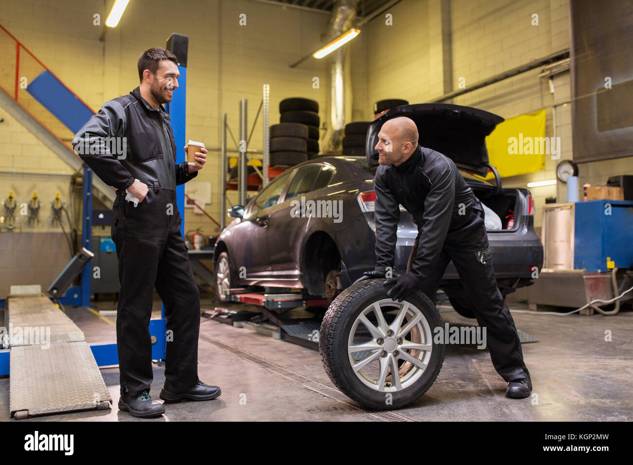 auto mechanics changing car tires at workshop Stock Photo - Alamy
