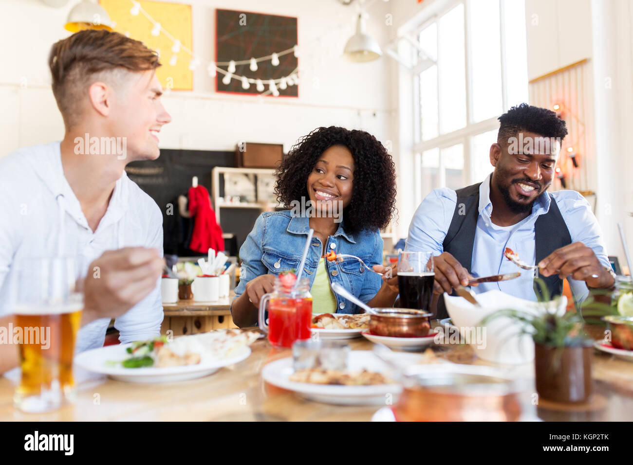 happy friends eating and talking at restaurant Stock Photo - Alamy