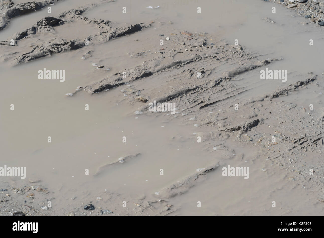 Muddy area of a car parking area. Visual metaphor for many saying ...