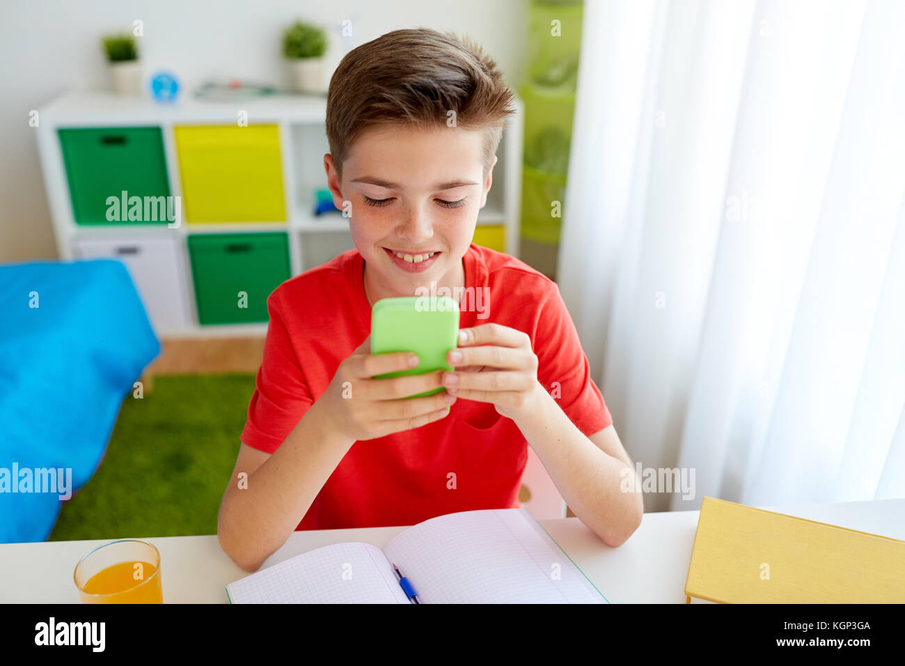 student boy with smartphone distracting from study Stock Photo - Alamy