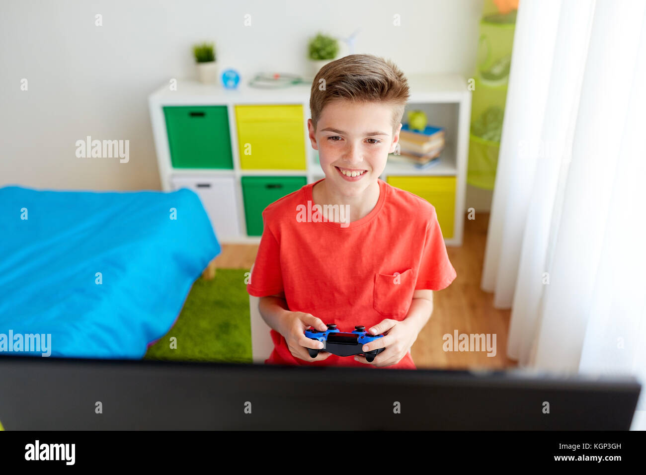 boy with gamepad playing video game on computer Stock Photo - Alamy
