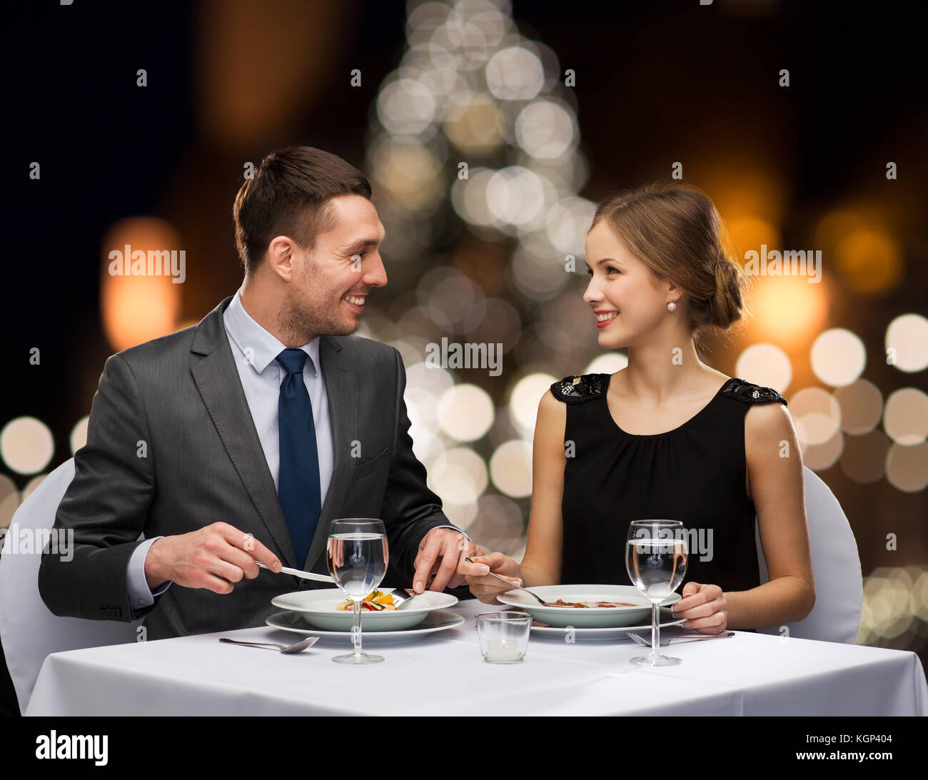 smiling couple eating at christmas restaurant Stock Photo - Alamy
