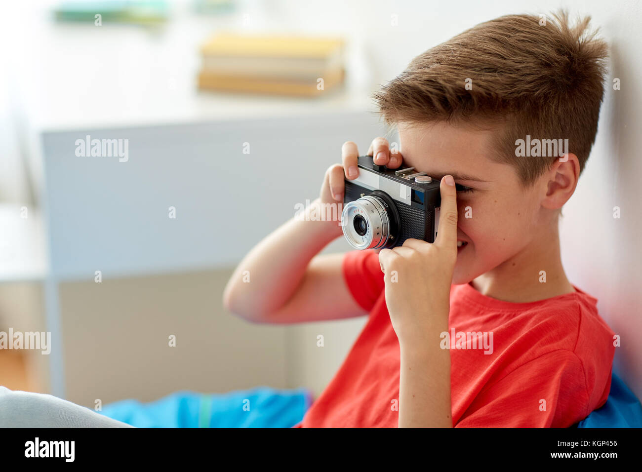 happy boy with film camera photographing at home Stock Photo - Alamy