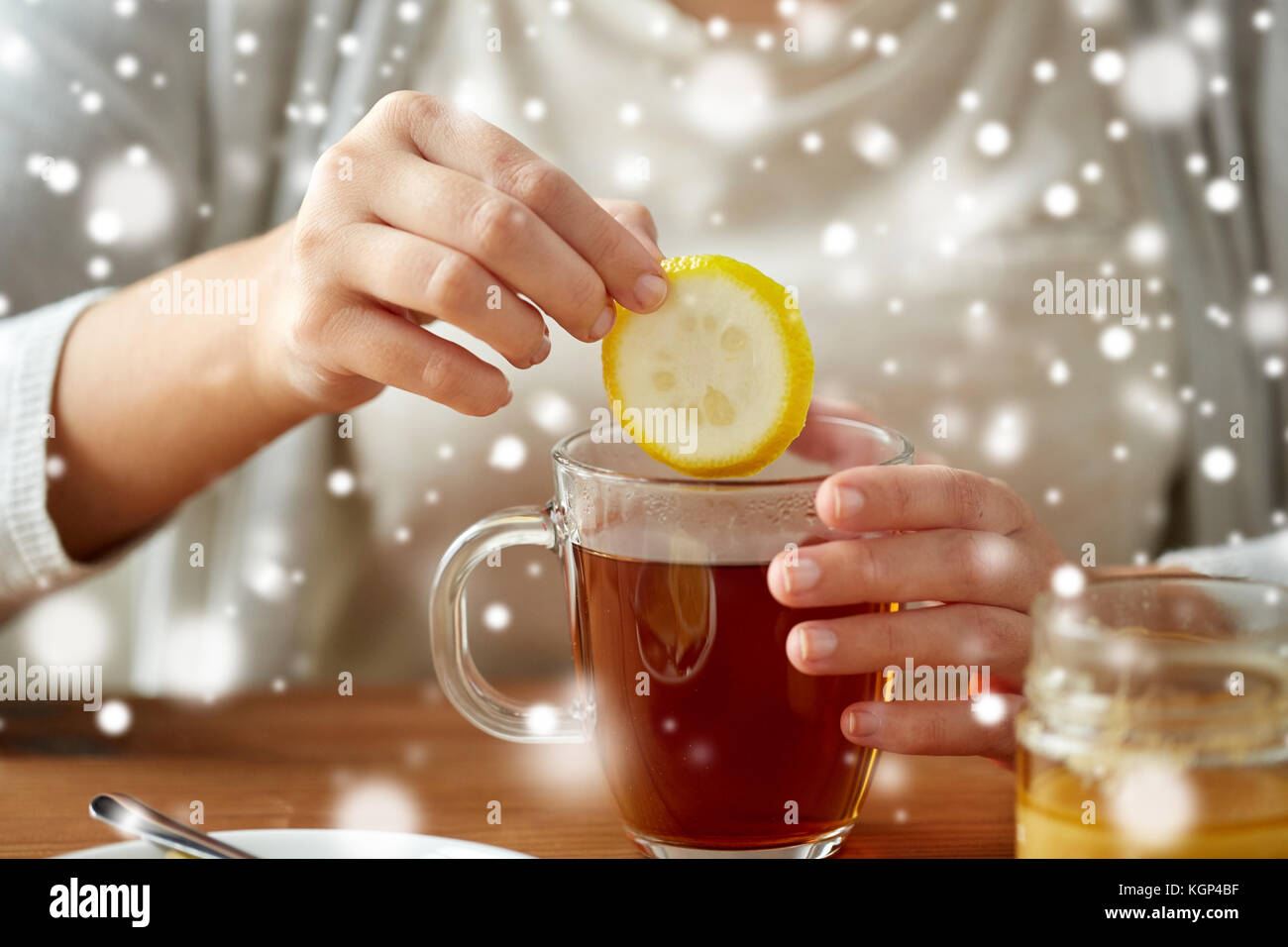 close up of woman adding lemon to tea with honey Stock Photo - Alamy
