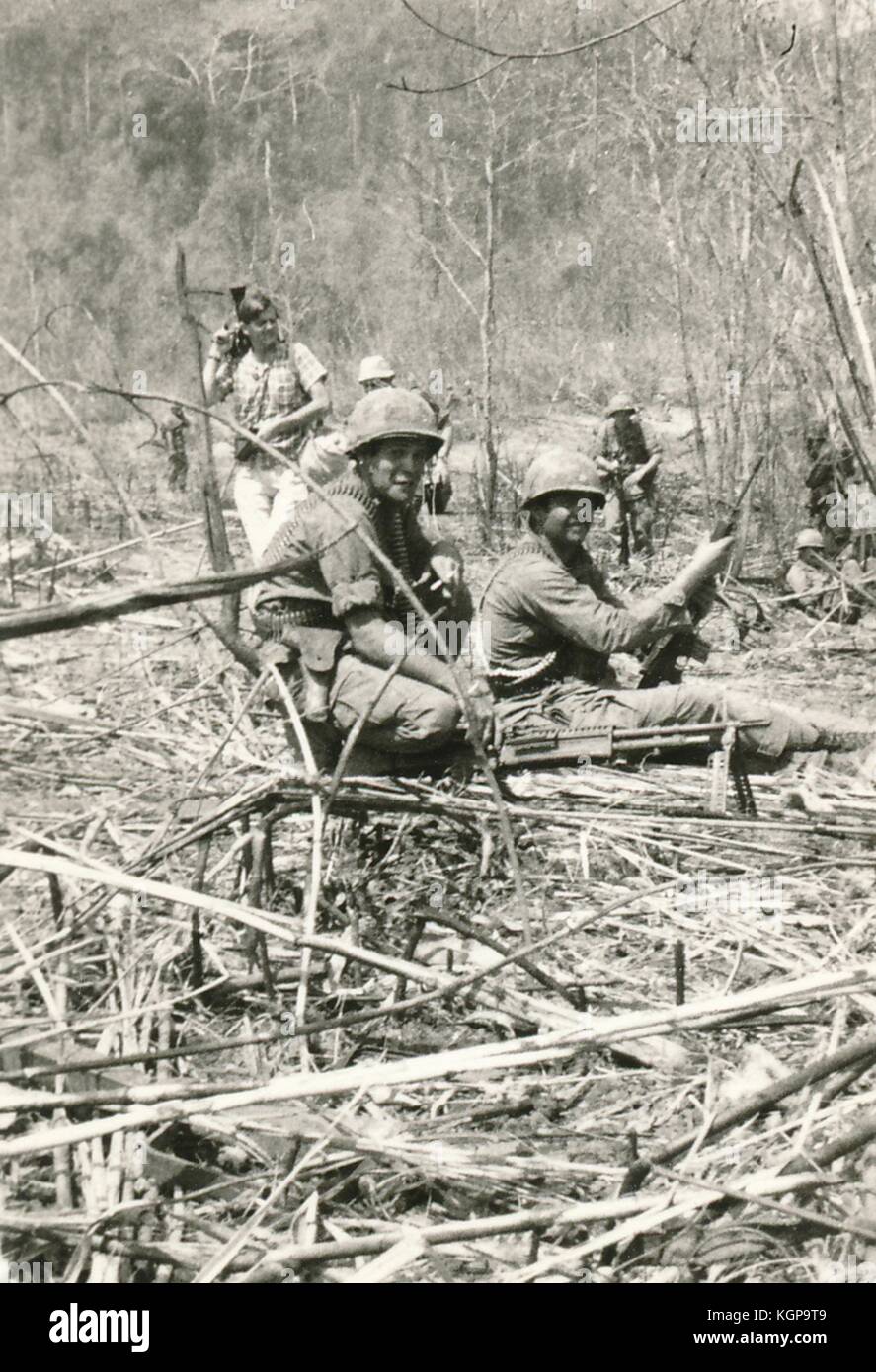 American soldiers with heavy machine guns crouch among plants in the ...