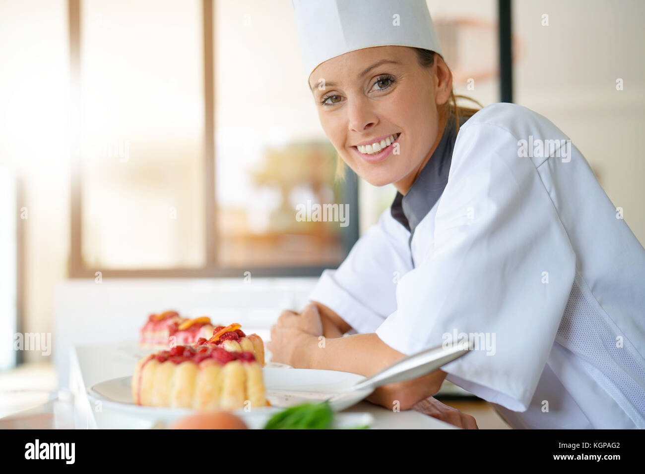 Smiling pastry chef standing in restaurant kitchen Stock Photo - Alamy