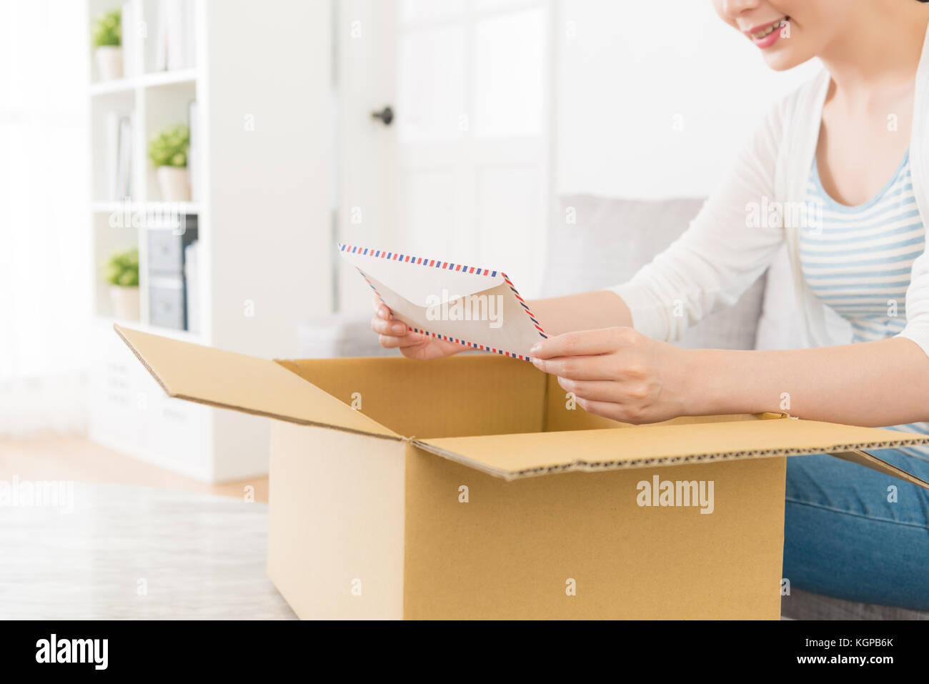 attractive young lady unpacking delivery parcel box at home and finding ...