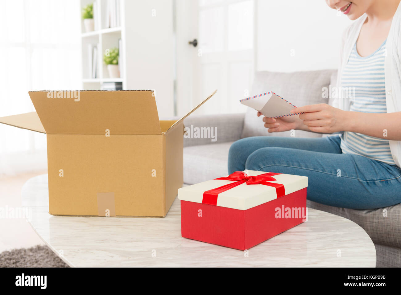 young elegant woman opening delivery parcel box at home and getting ...
