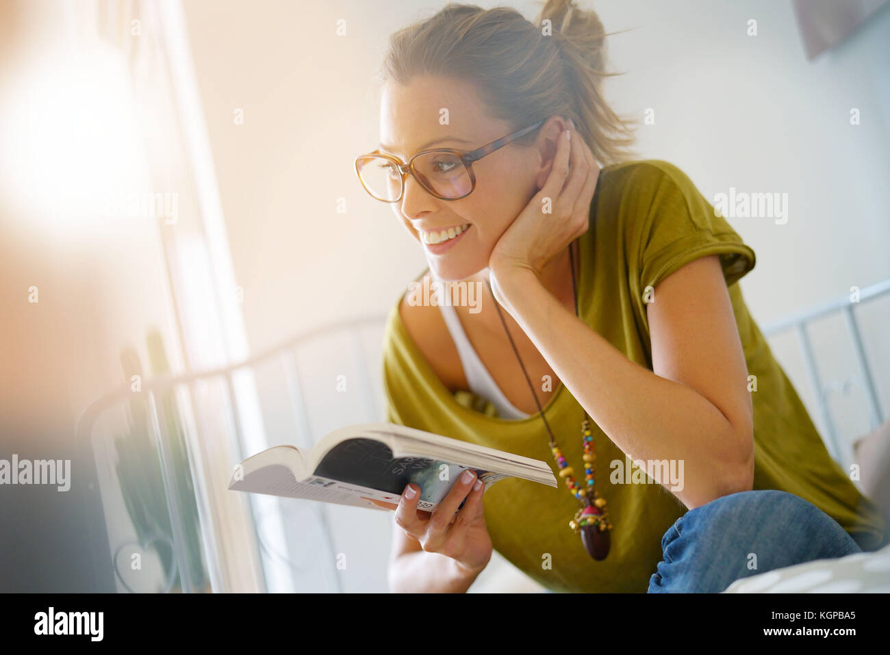 Trendy girl relaxing in sofa and reading book Stock Photo - Alamy