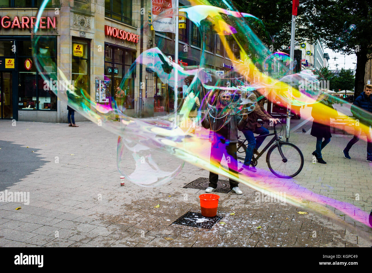 A street entertainer makes huge bubbles to amuse children and other ...