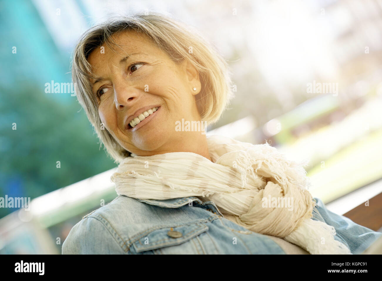 Portrait of smiling senior woman sitting on bench Stock Photo - Alamy