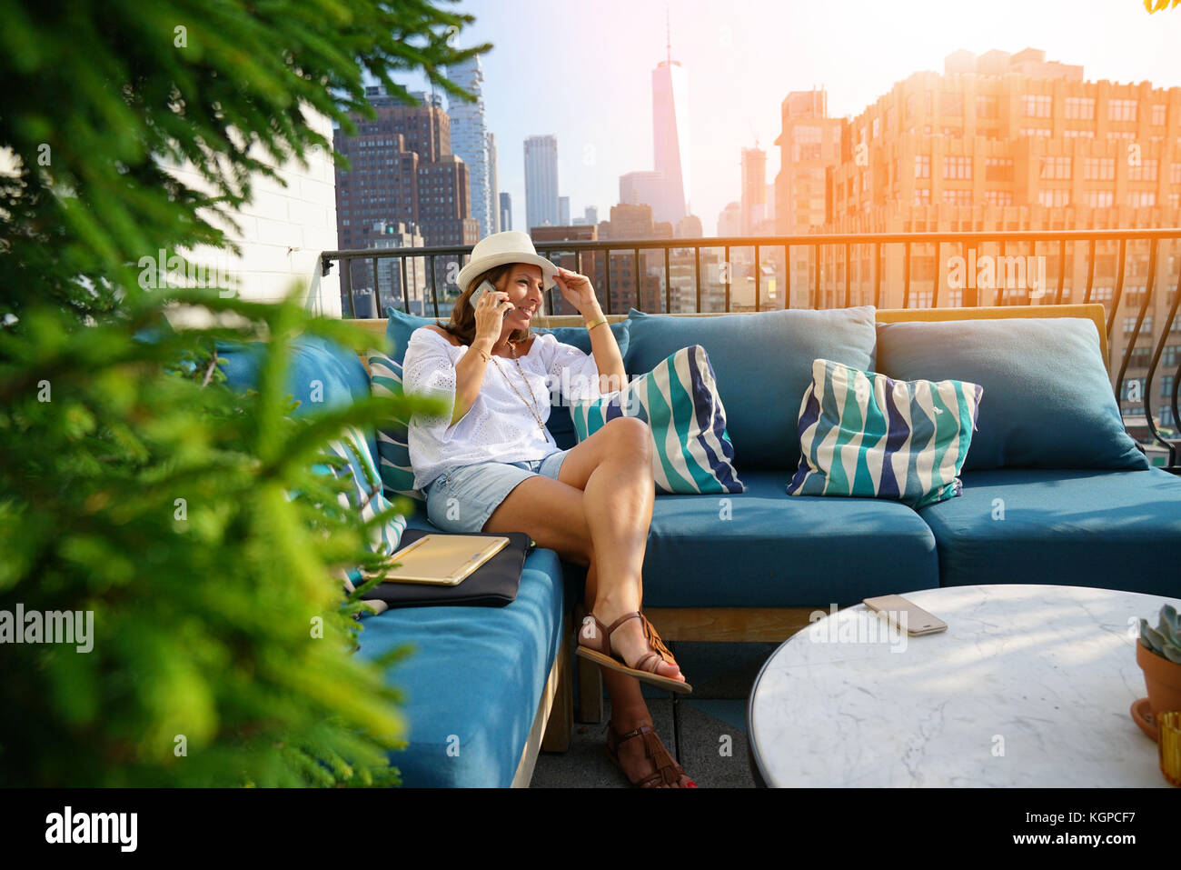 Woman relaxing in sofa on rooftop, NYC Stock Photo - Alamy