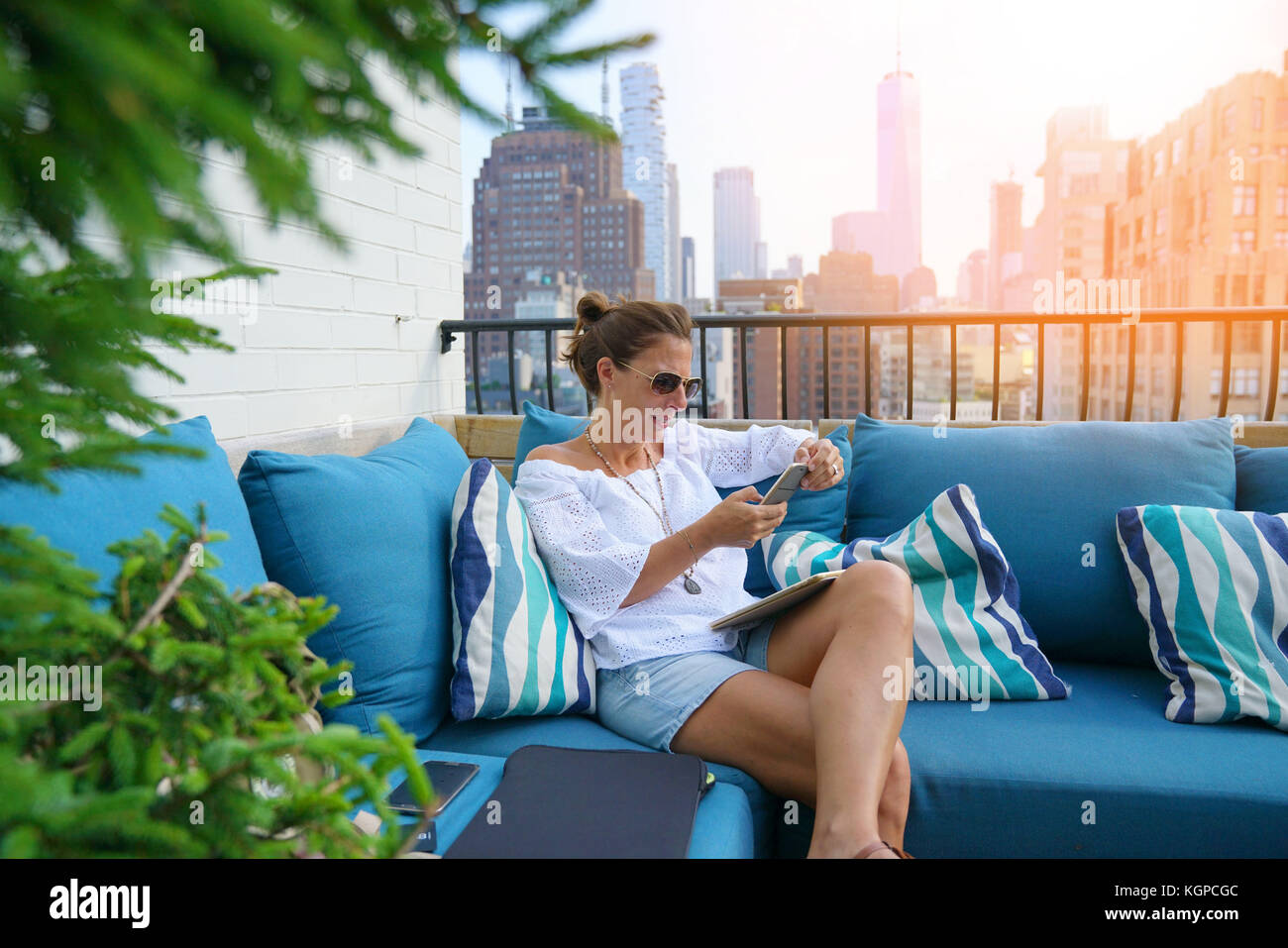 Woman relaxing in sofa on rooftop, NYC Stock Photo - Alamy