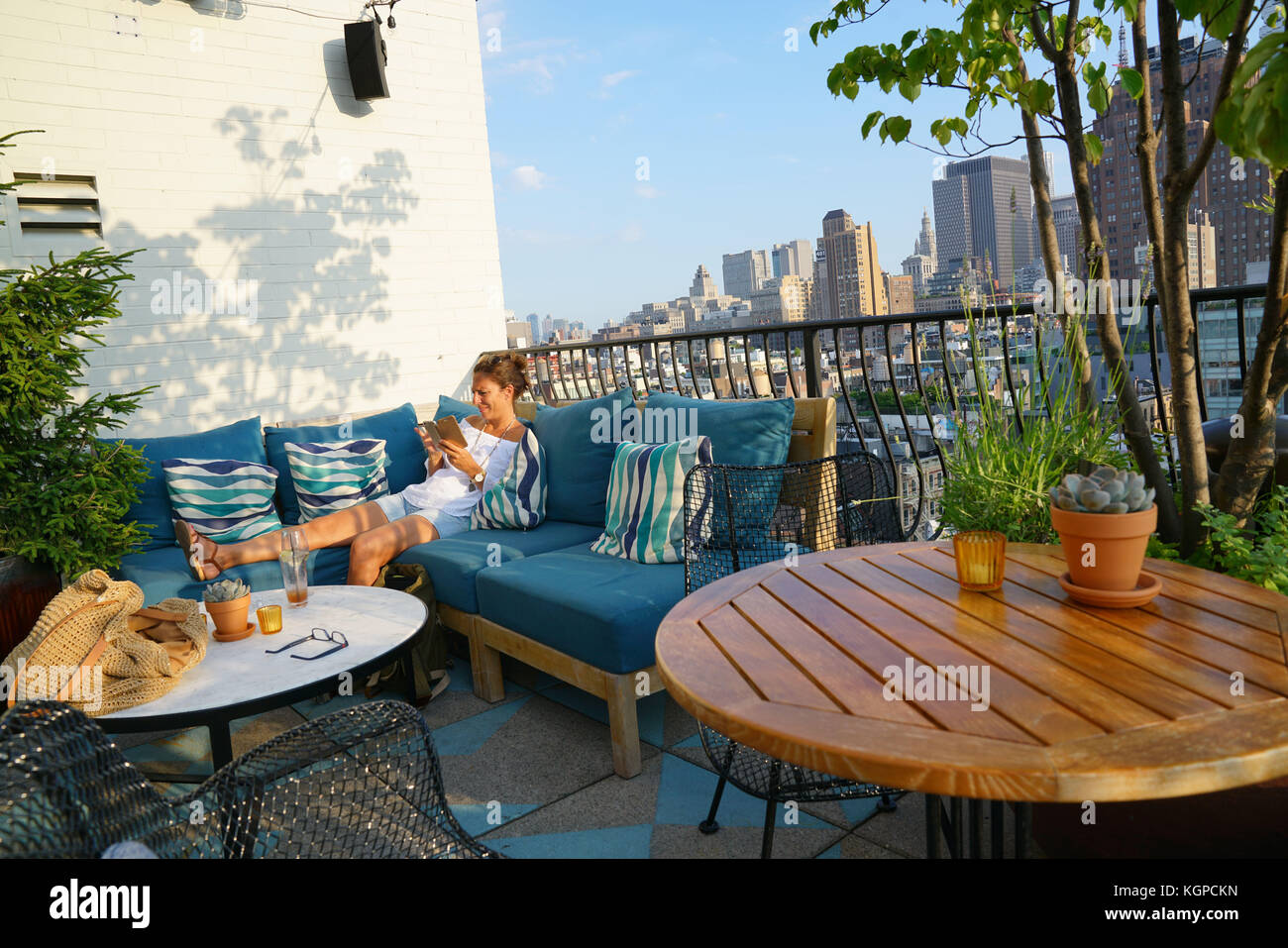 Woman relaxing in sofa on rooftop, NYC Stock Photo - Alamy