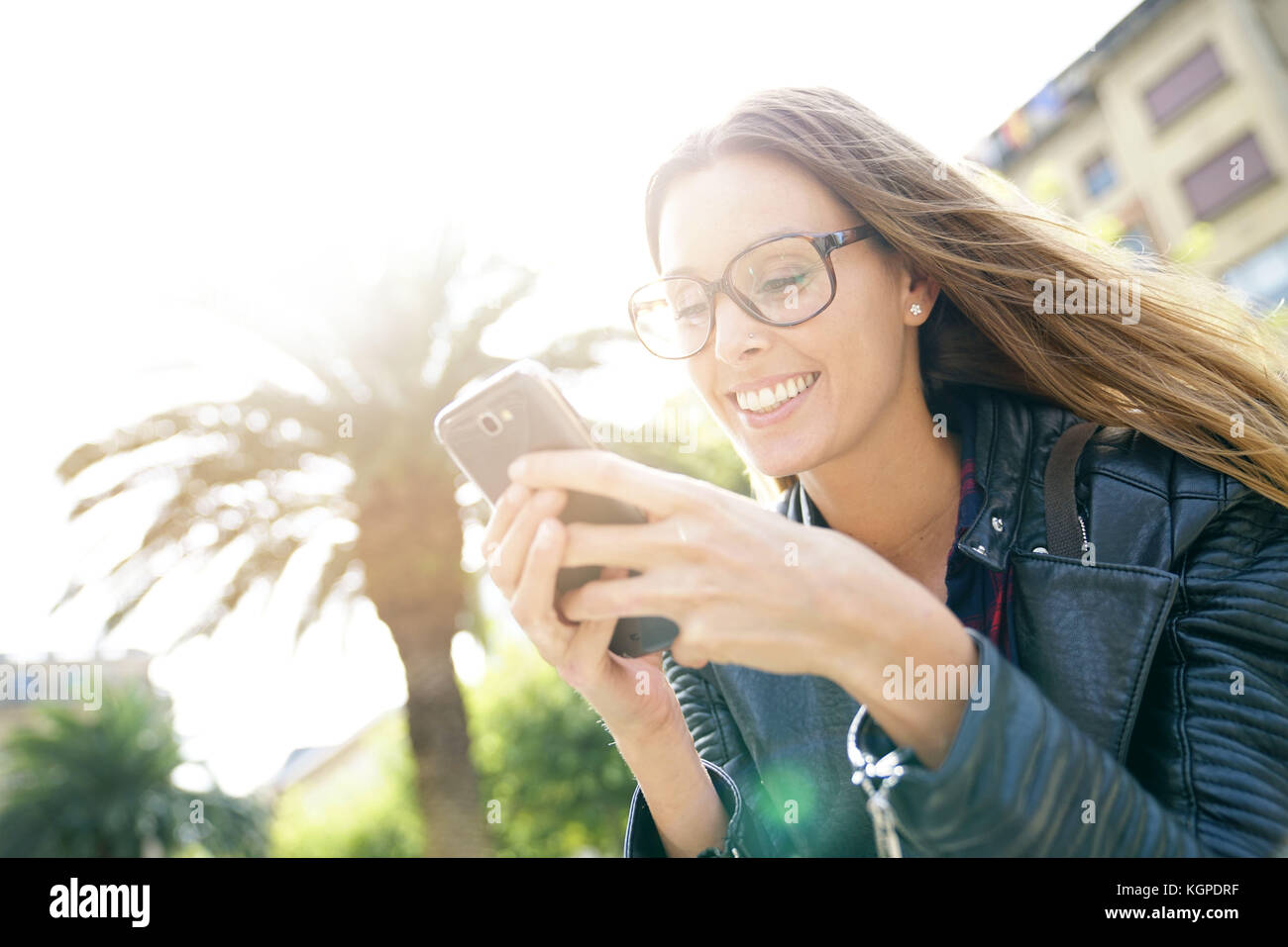 Portrait of trendy girl in town using smartphone Stock Photo - Alamy