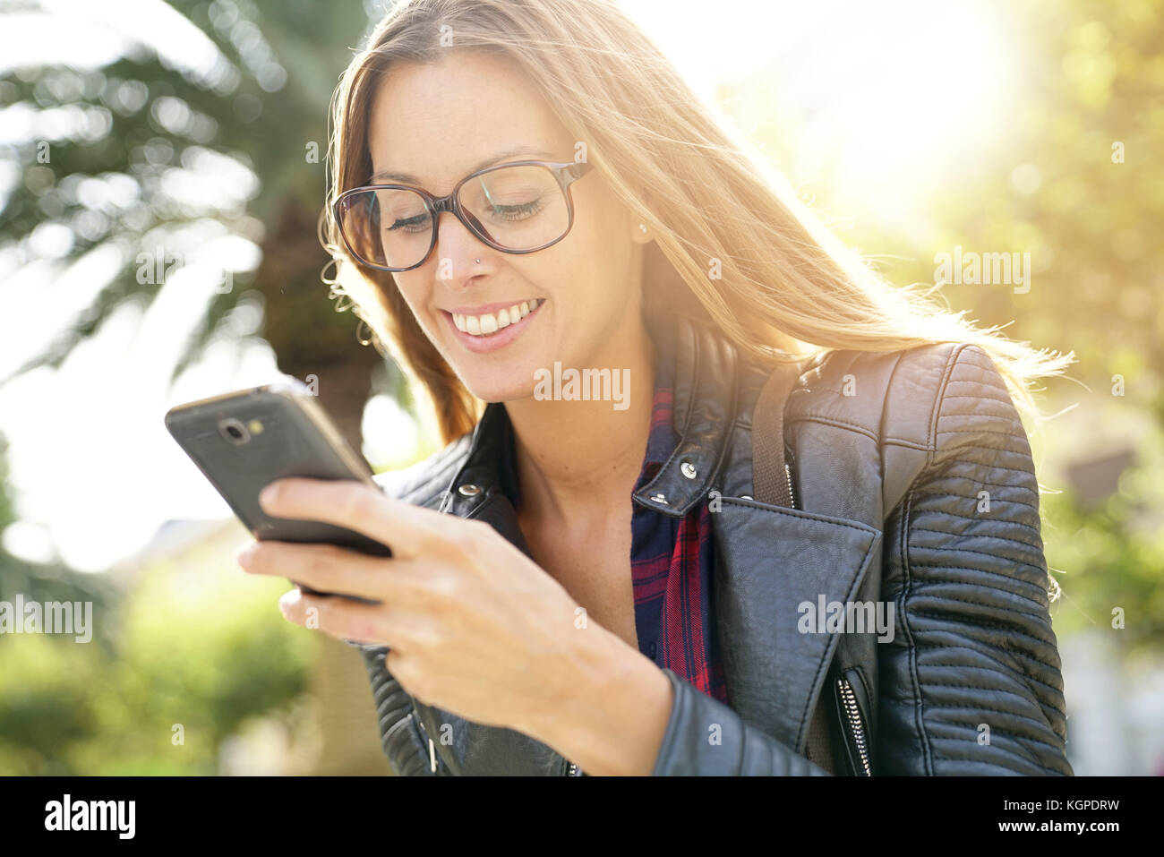 Portrait of trendy girl in town using smartphone Stock Photo - Alamy