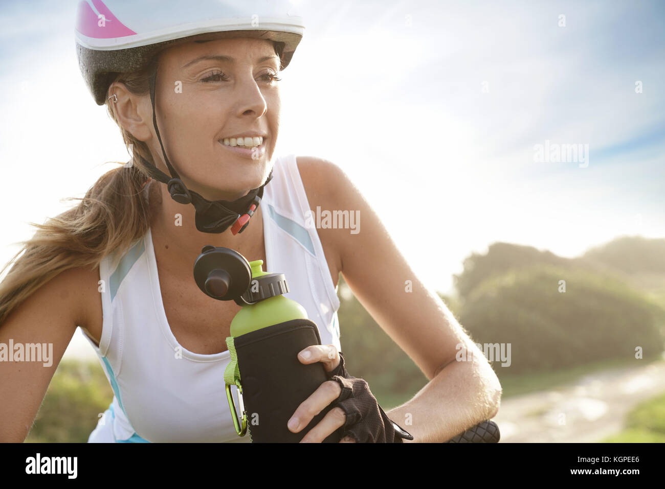 Portrait of woman on biking journey drinking water from bottle Stock ...