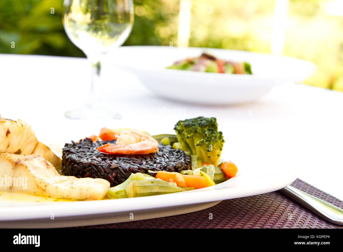 Fish with black rice, vegetables and prawn Stock Photo - Alamy