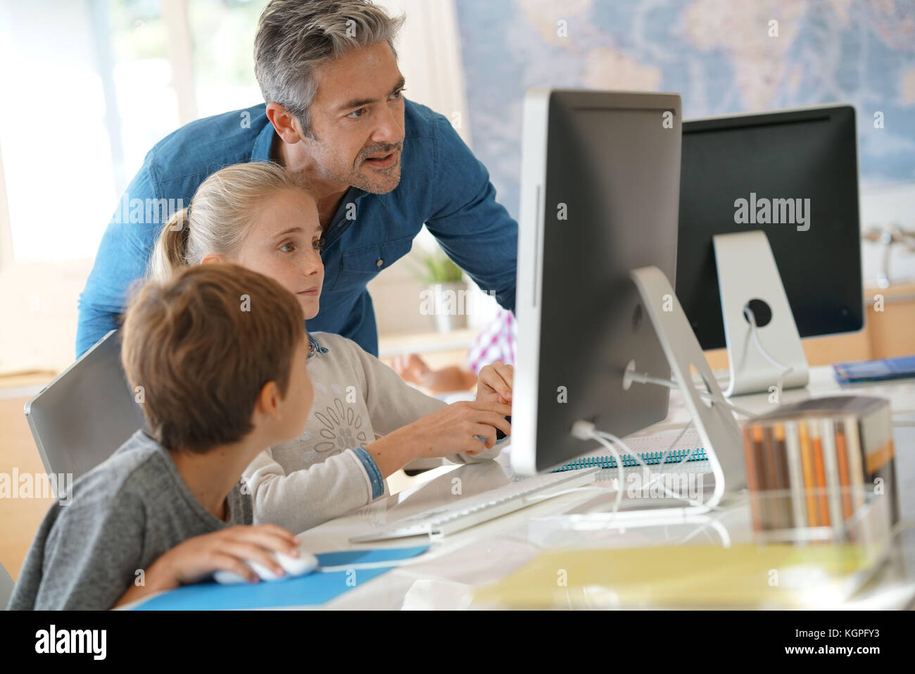 Teacher with school kids in computer laboratory Stock Photo - Alamy