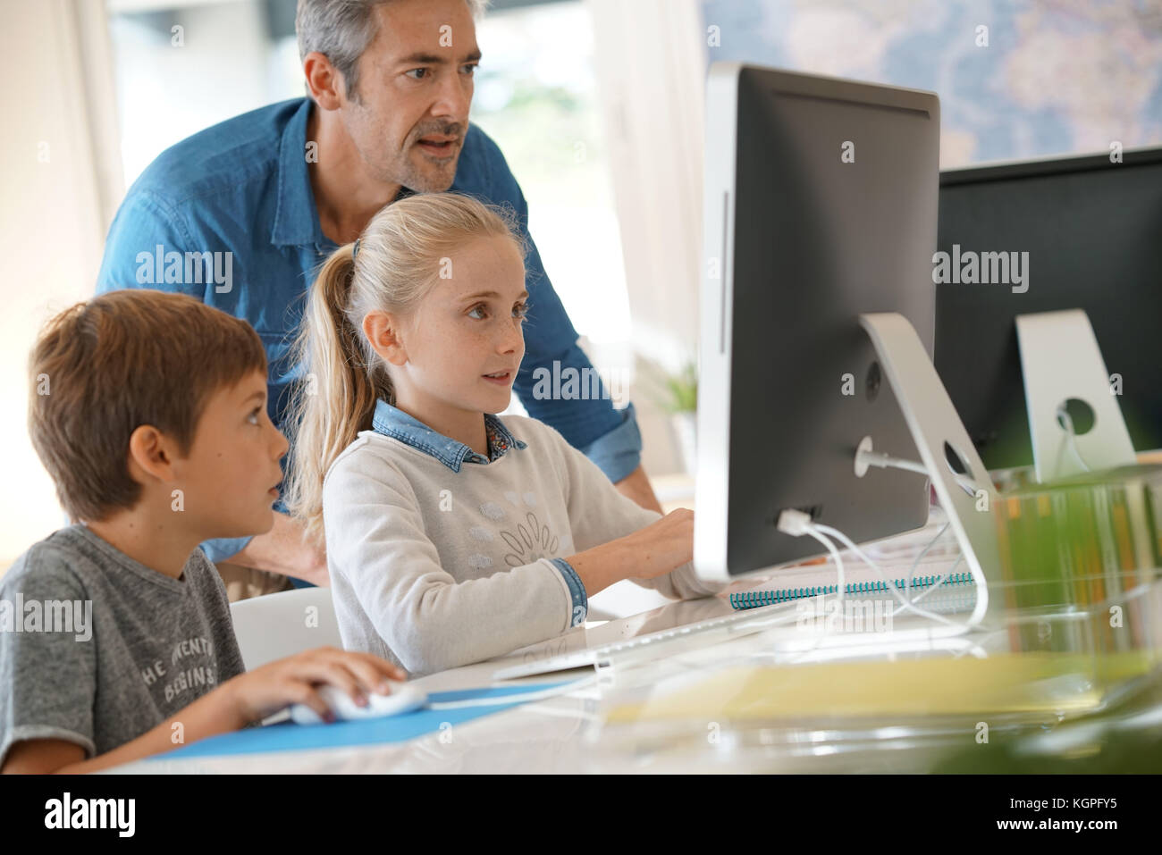 Teacher with school kids in computer laboratory Stock Photo - Alamy