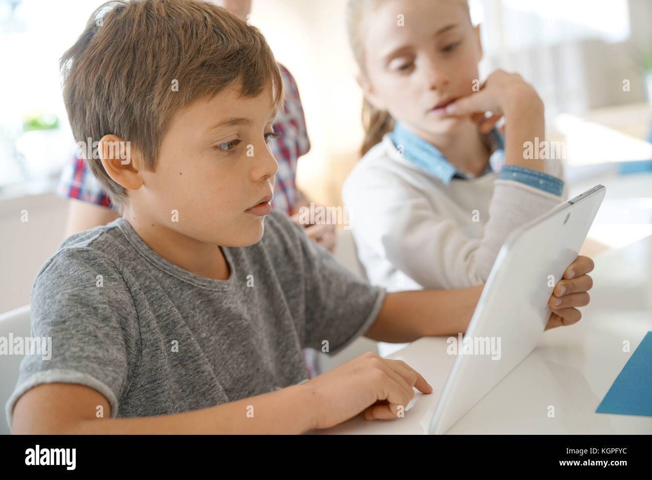 Kids in class working on digital tablet Stock Photo - Alamy