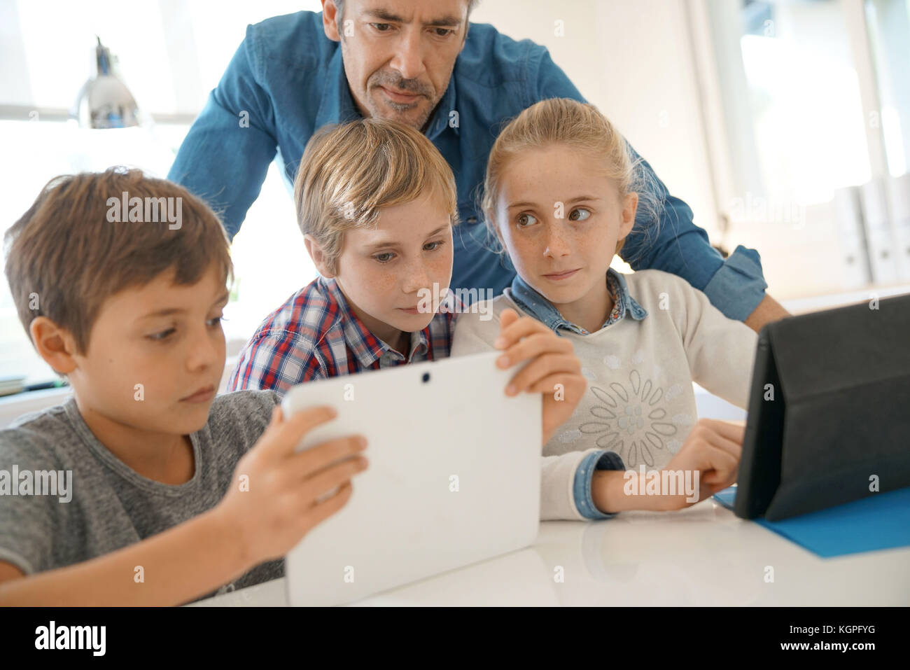 Kids in classroom learning with digital tablet Stock Photo - Alamy