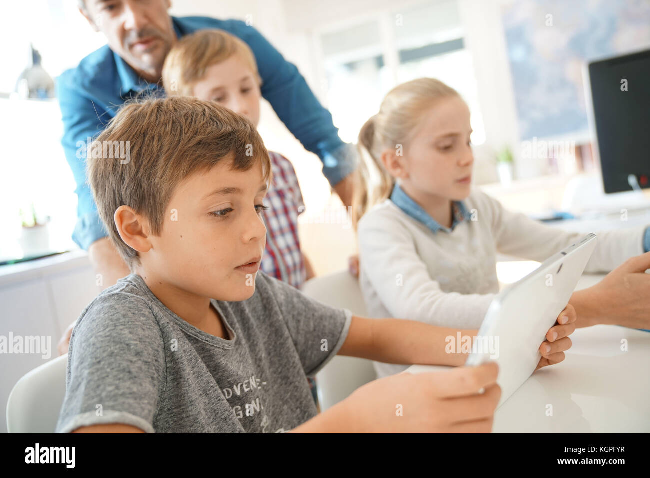 Kids in classroom learning with digital tablet Stock Photo - Alamy