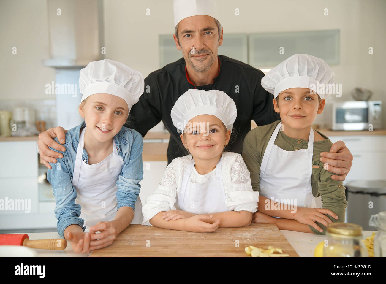 Portrait of happy pastry chef together with kids in cooking class Stock ...