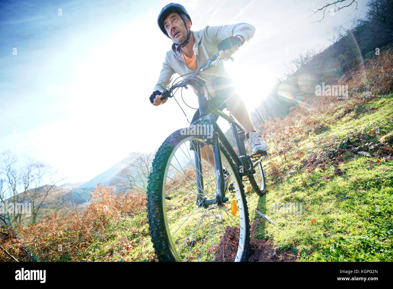 Mature man riding bike in the mountain Stock Photo - Alamy
