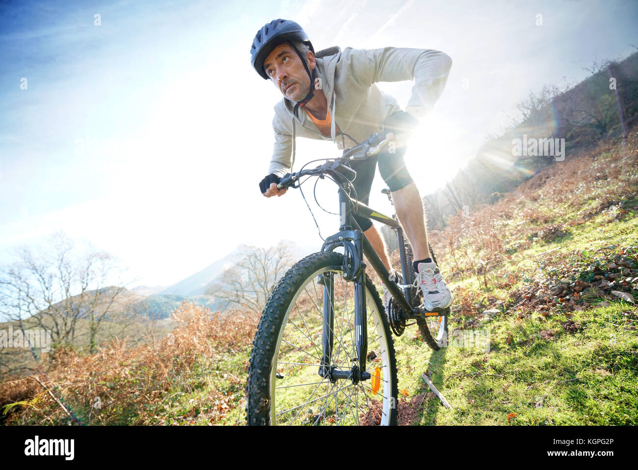 Mature man riding bike in the mountain Stock Photo - Alamy