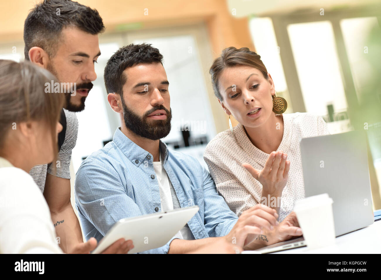 Design team meeting and working on laptop Stock Photo - Alamy