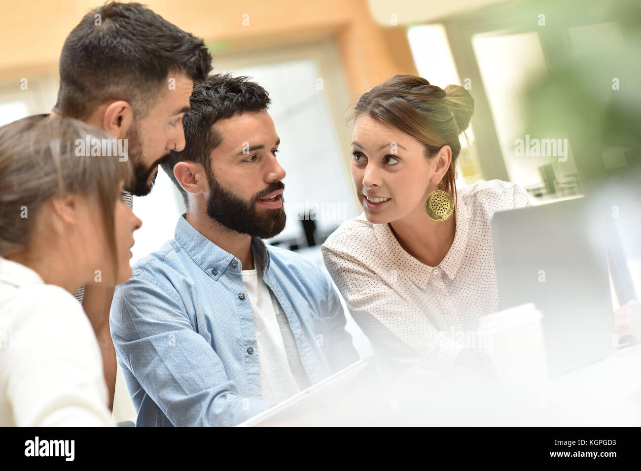 Design team meeting and working on laptop Stock Photo - Alamy