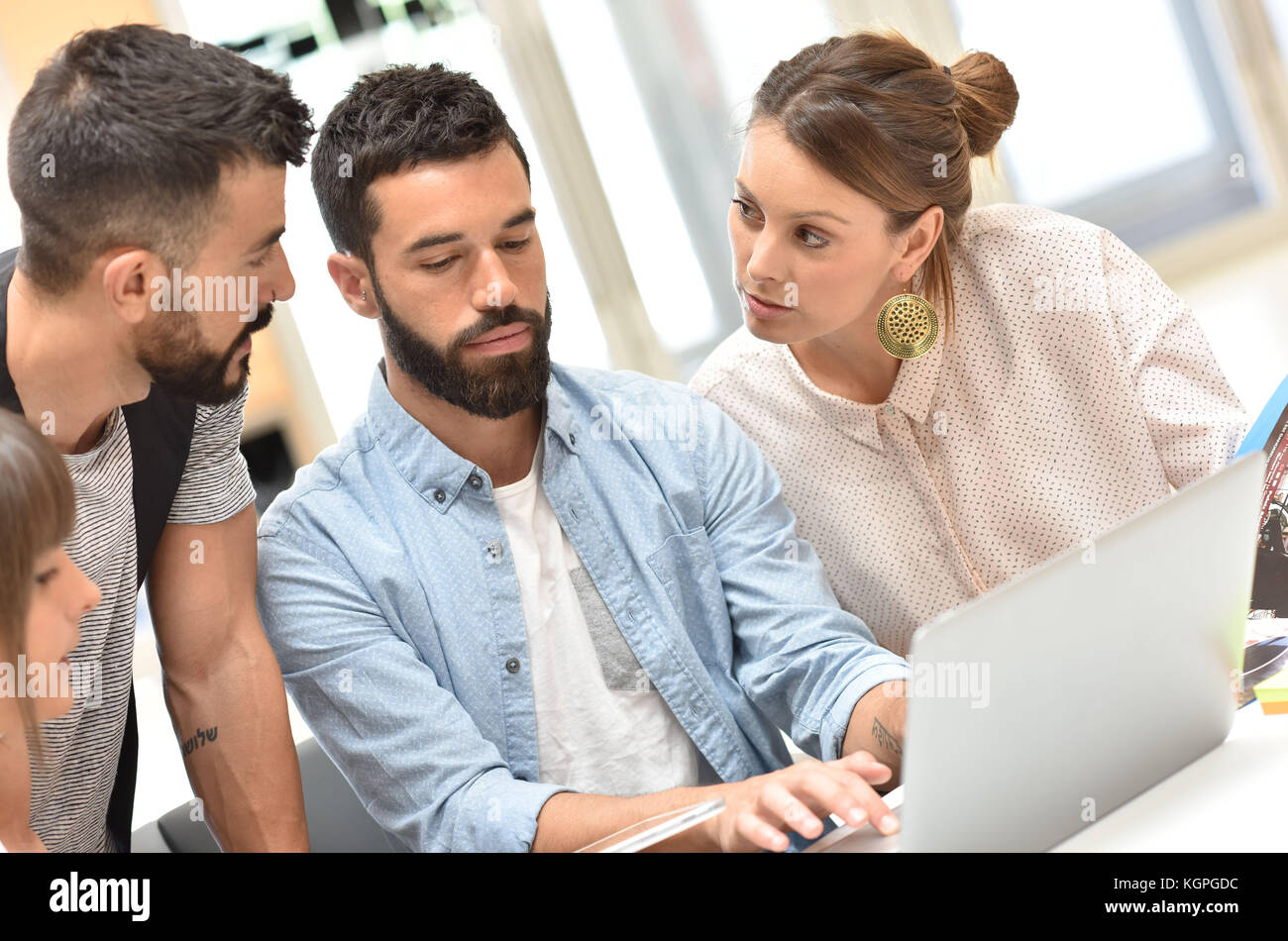 Design team meeting and working on laptop Stock Photo - Alamy