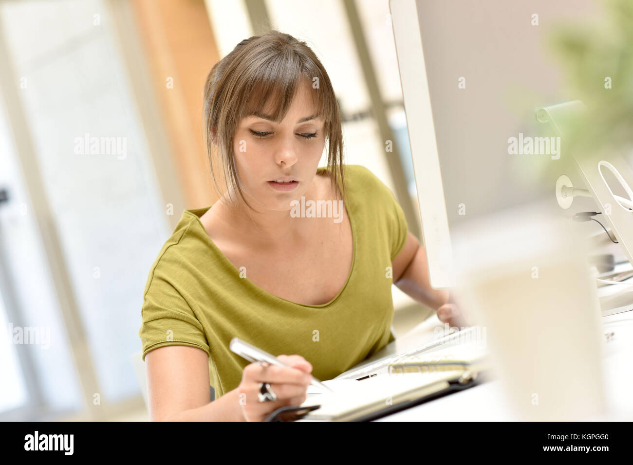 Portrait of office worker in front of desktop Stock Photo - Alamy